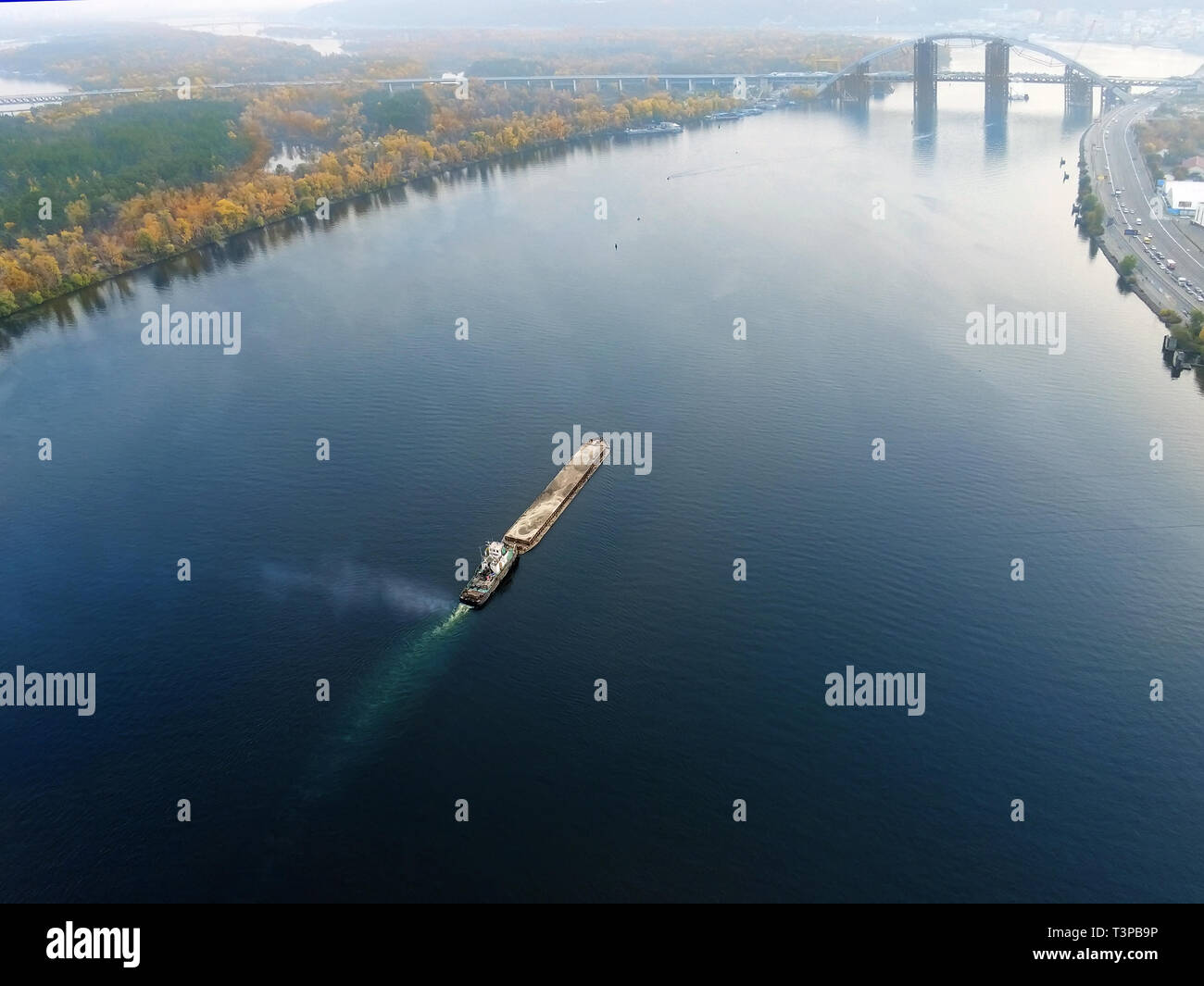 Scenic aerial cityscape of Kiev and river Dnipro at sunset. Tugboat ...
