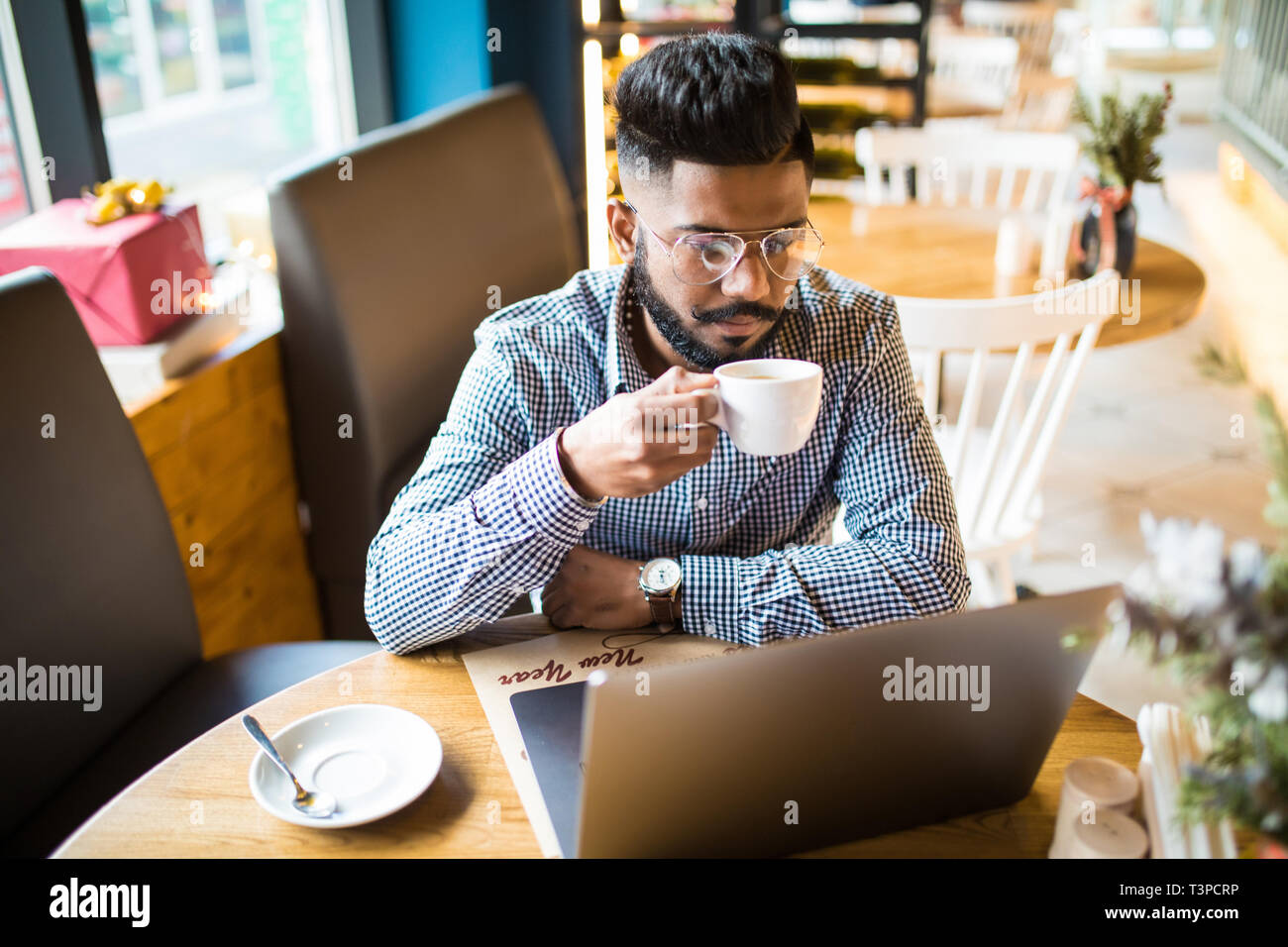 Young indian man drinking coffee in cafe and laptop in cafe Stock Photo ...