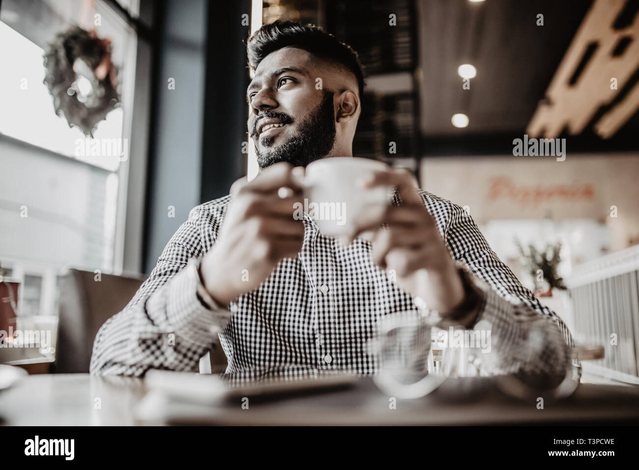 Young indian male drinking coffee in cafe Stock Photo - Alamy