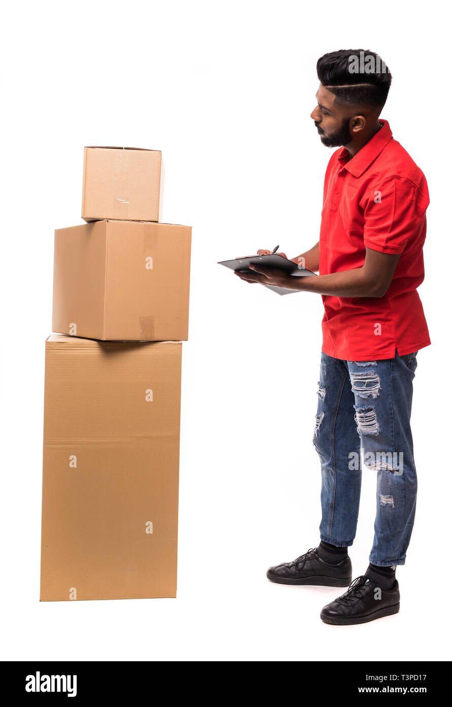 Handsome young indian delivery man standing with parcel post boxes ...