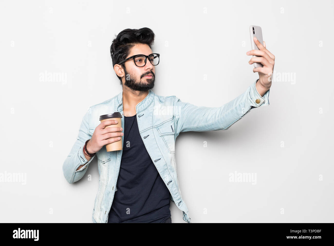 Smiling young guy taking selfie photo on smartphone. Indian man using digital device. Selfie ...