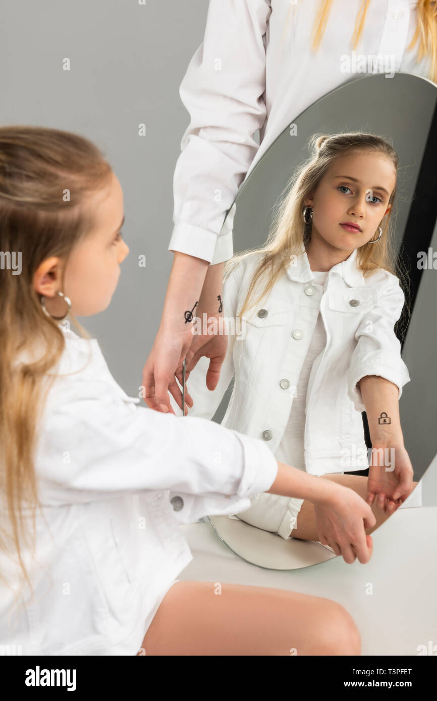 Emotionless young kid observing picture on her hand Stock Photo - Alamy