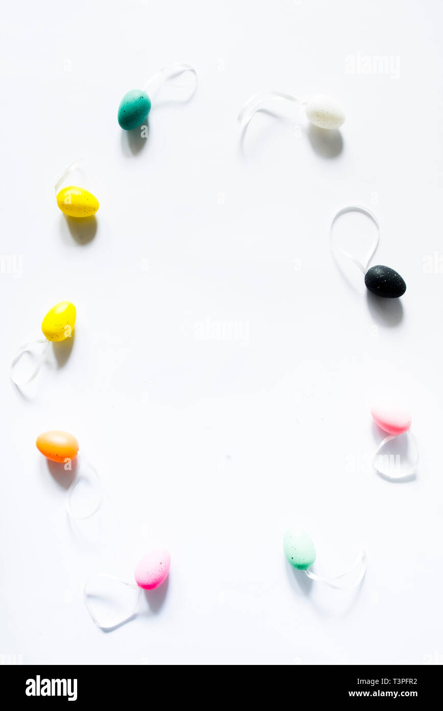 Colorful small eggs arranged in a circle egg shaped on a white ...