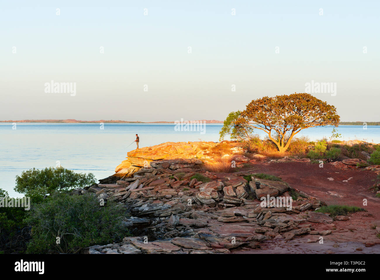 Lone fisherman standing on rock outcrop, Cape Leveque, Dampier ...