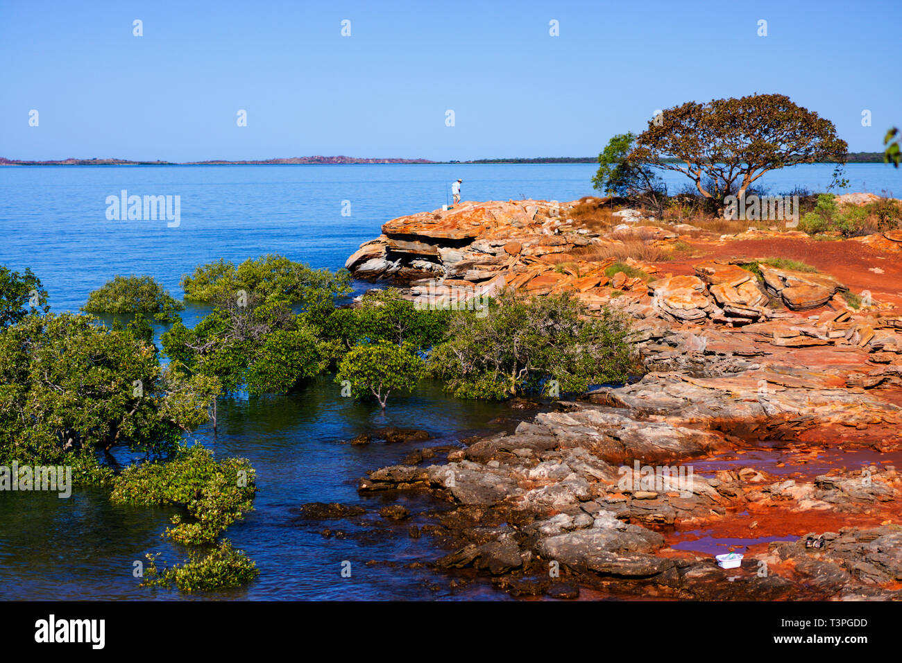 Lone fisherman standing on rock outcrop, Cape Leveque, Dampier ...