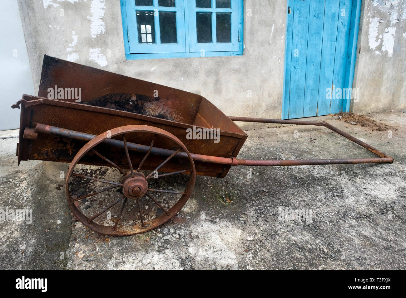 Old farm cart with two whells standing near house Stock Photo - Alamy