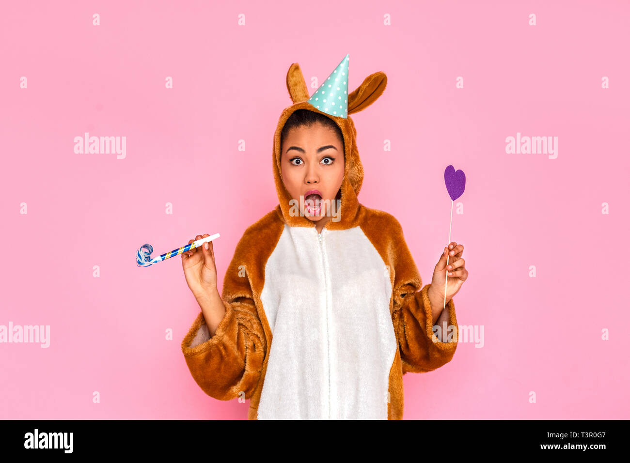 Young Woman In Bunny Kigurumi Wearing Party Hat Standing Isolated On