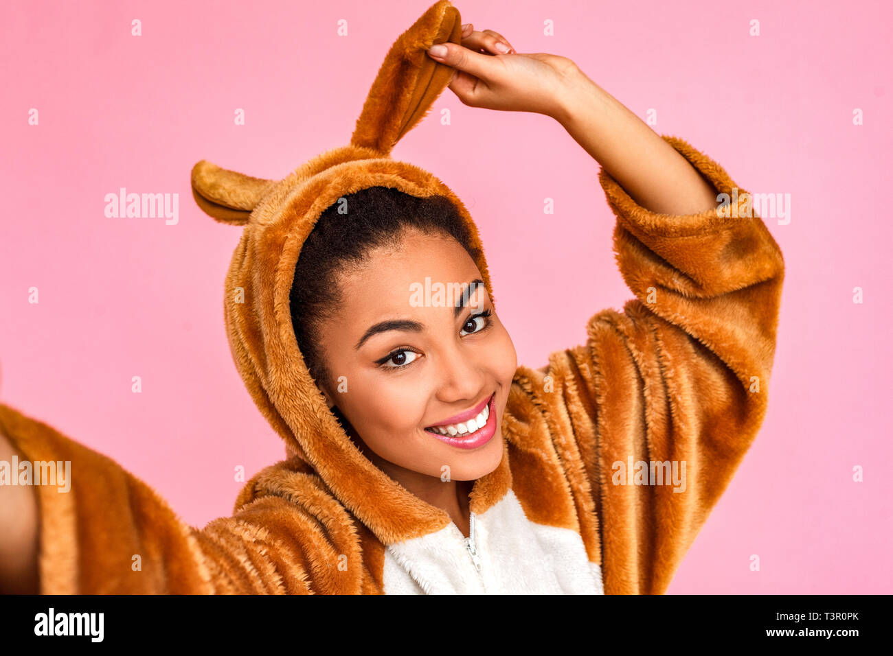 Young Woman In Bunny Kigurumi Standing Isolated On Pink Background