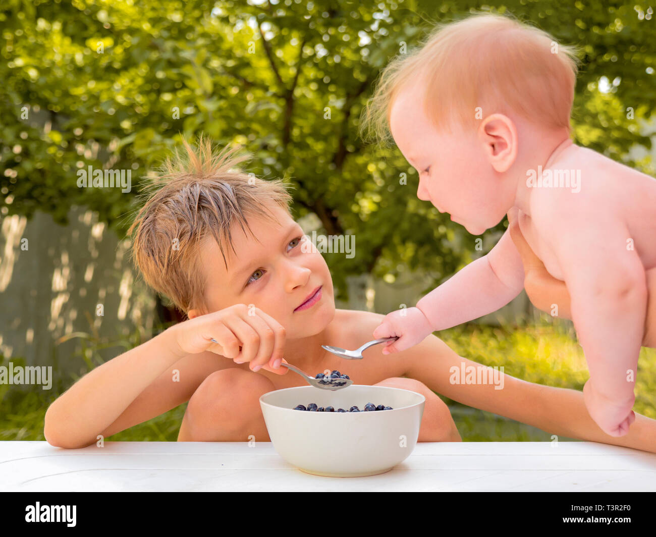 Sibings eating fresh juicy berries. Happy childhood concept. Healthy ...