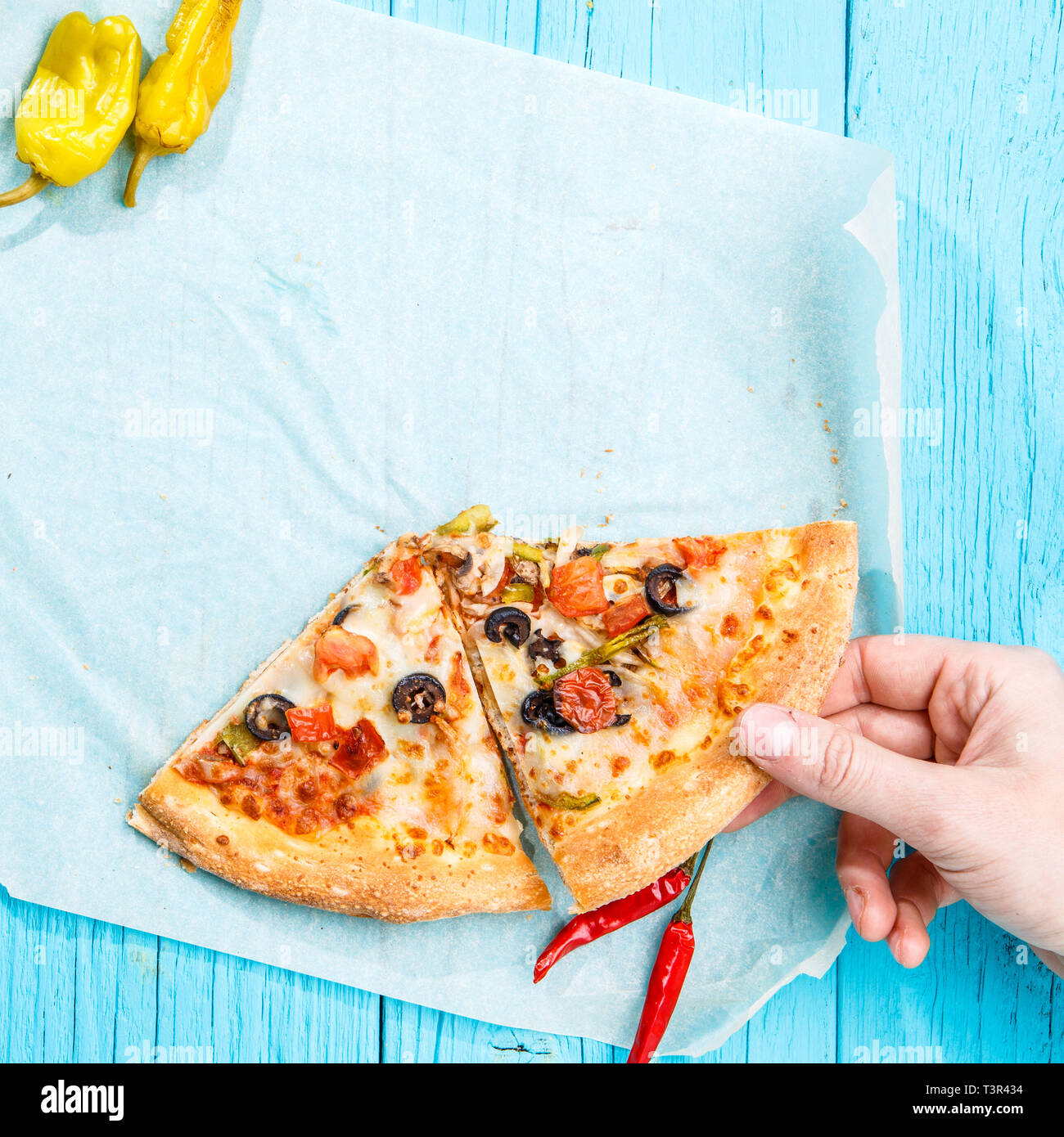Image of pizza on table. Man take slice Stock Photo - Alamy