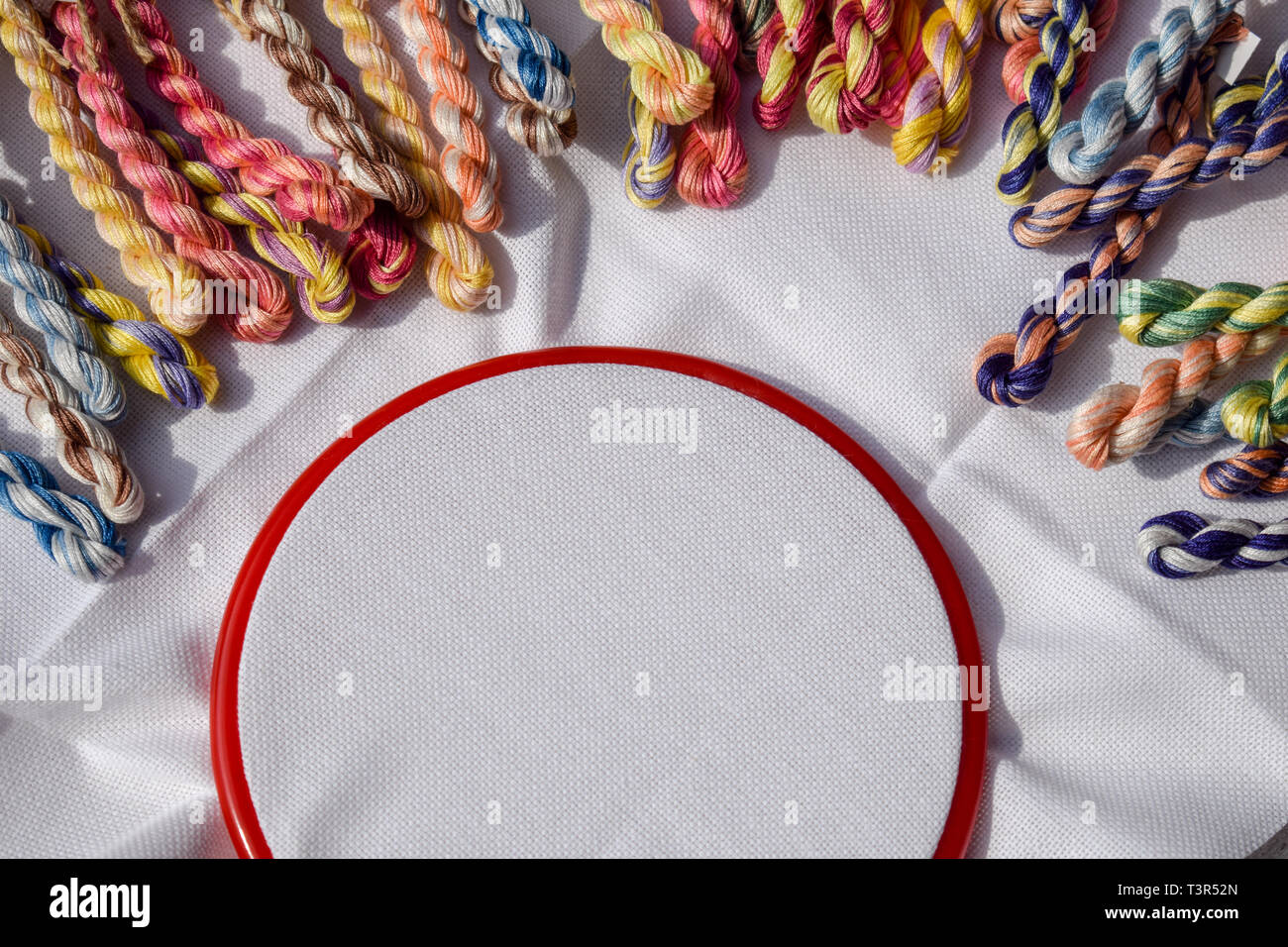The embroidery hoop with canvas and colored sewing threads Stock Photo ...