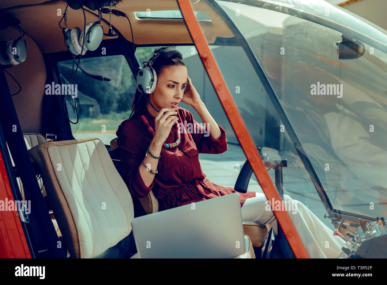 Serious experienced female pilot having connection with flight operator ...