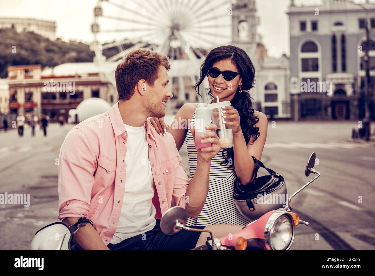 Joyful positive couple cheering with their drinks Stock Photo - Alamy