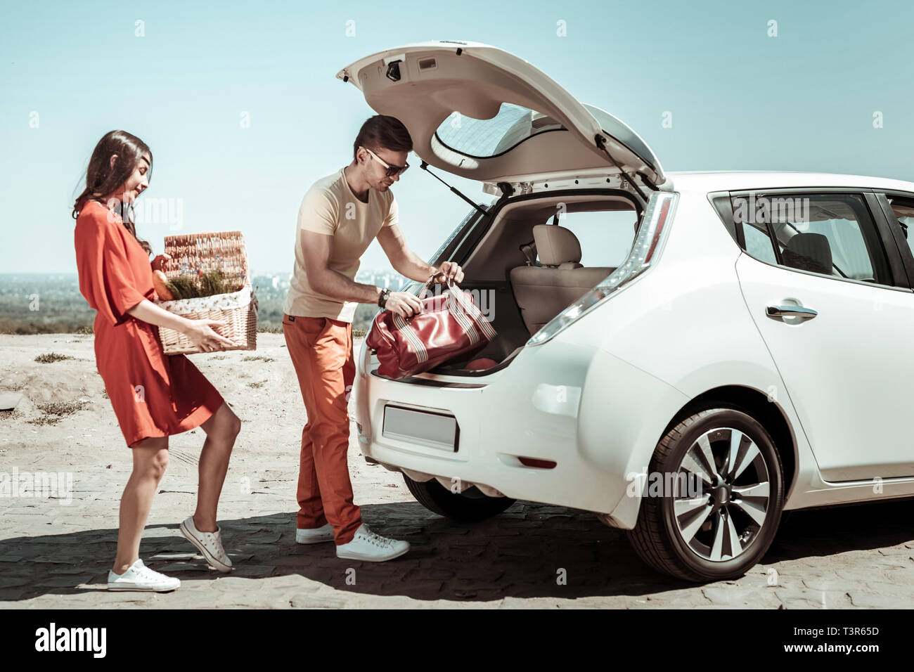 Handsome brunette man taking bag from trunk Stock Photo - Alamy