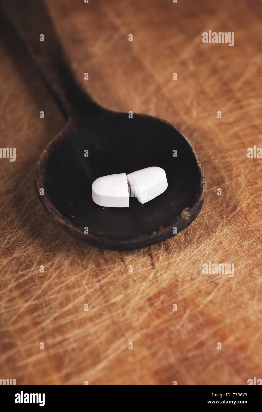 Broken pill medicine tablet on wooden spoon as adrug abuse concept ...