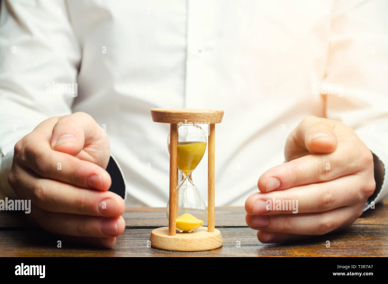 Man protects the hourglass. Concept of saving time and money. Time ...