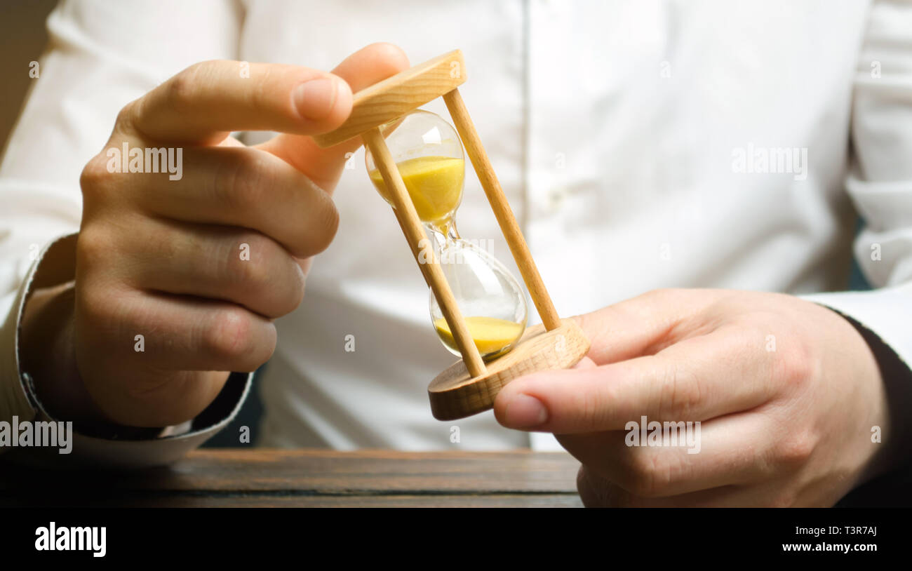 Businessman holds clock in hands. Concept of saving time and money ...