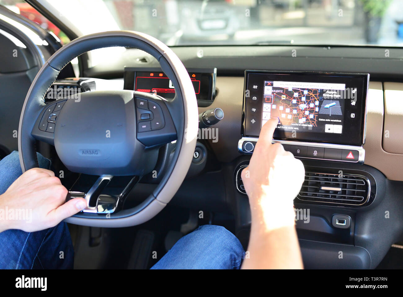 man operates navigation device in car in a car dealership and tests it ...