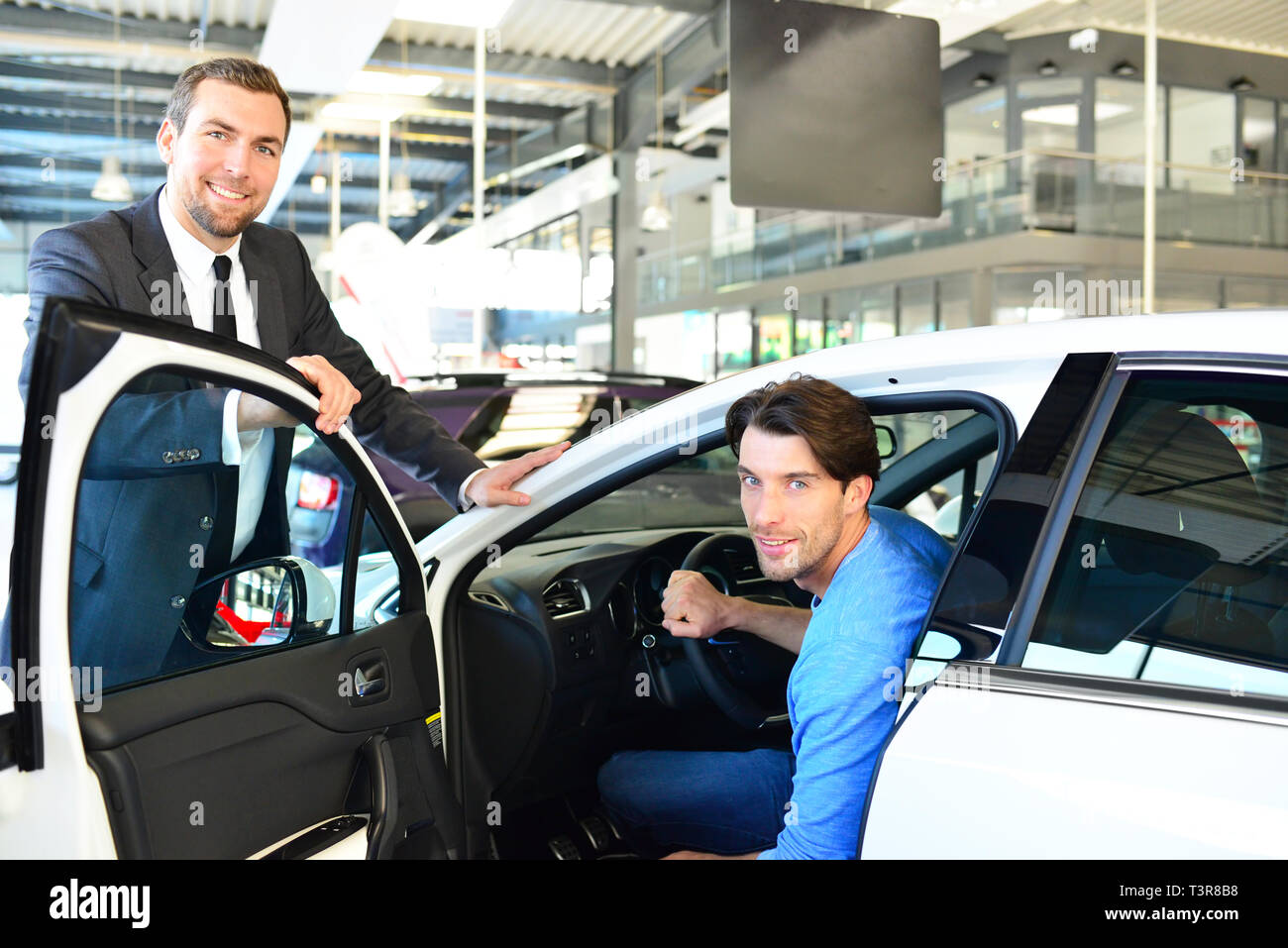 man and seller talking at the dealership about the technology of a new ...