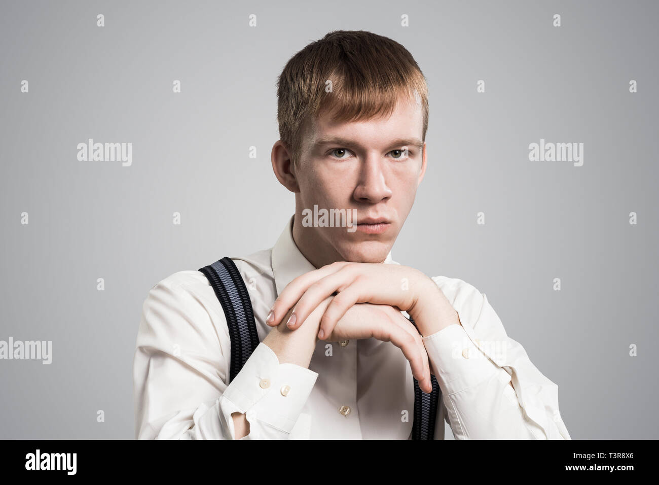 Sad young guy with arms touching his chin Stock Photo - Alamy
