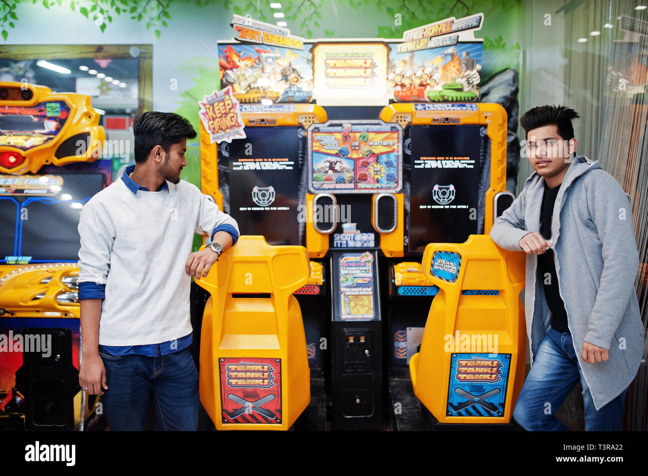 Two asian guys compete on speed rider arcade game racing simulator ...