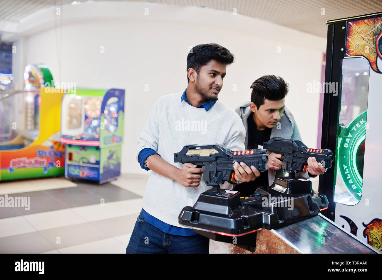 Two asian guys compete on shooter simulator game arcade machine Stock ...