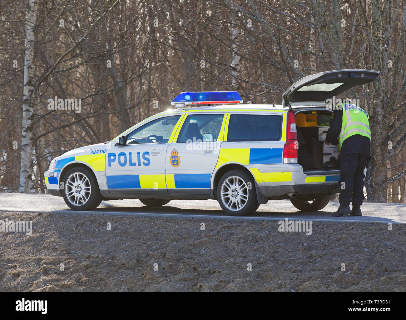 A police officer at a police car on a country road Stock Photo - Alamy