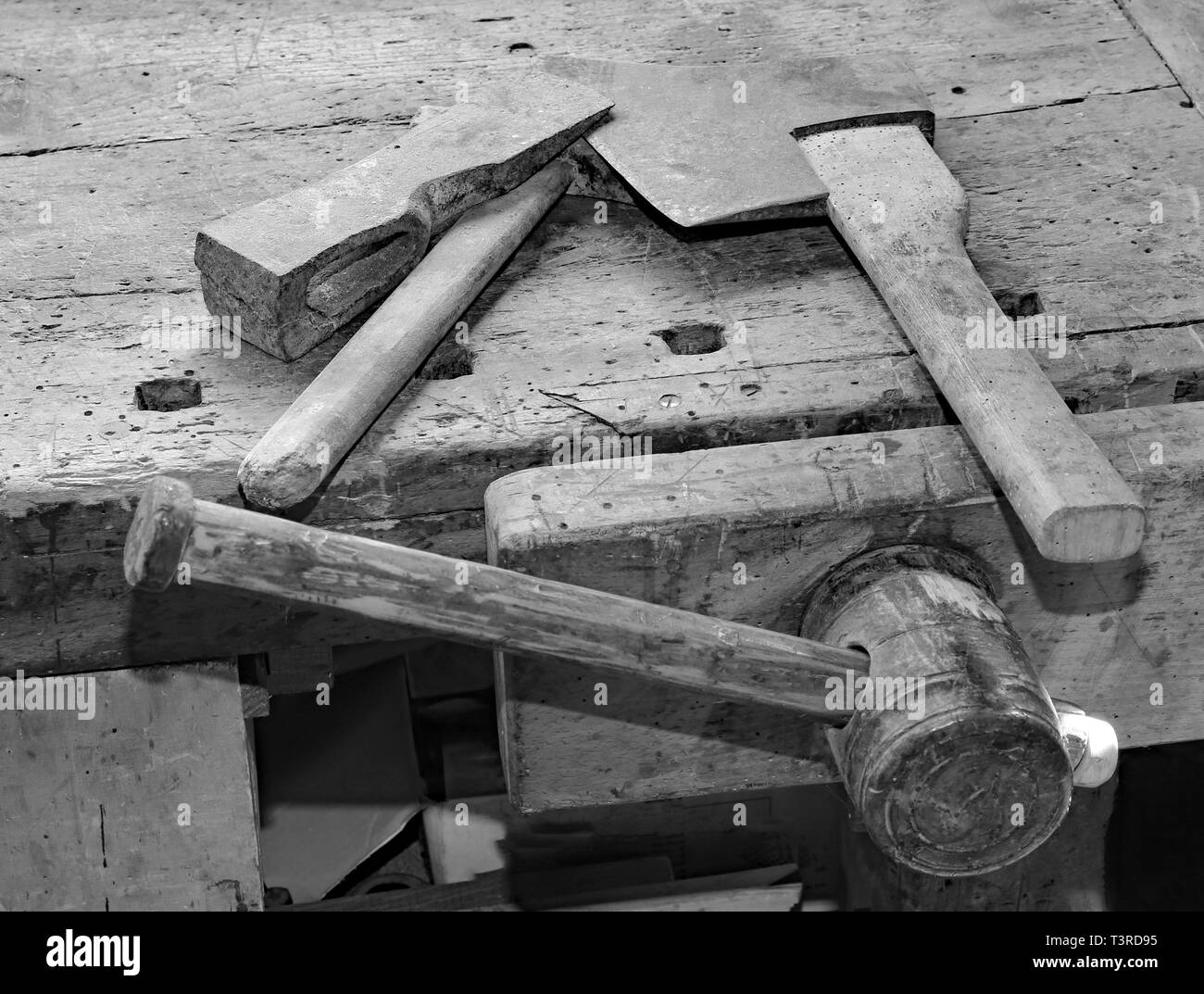ancient tools small axe and big hammer on the old wooden workbench with ...