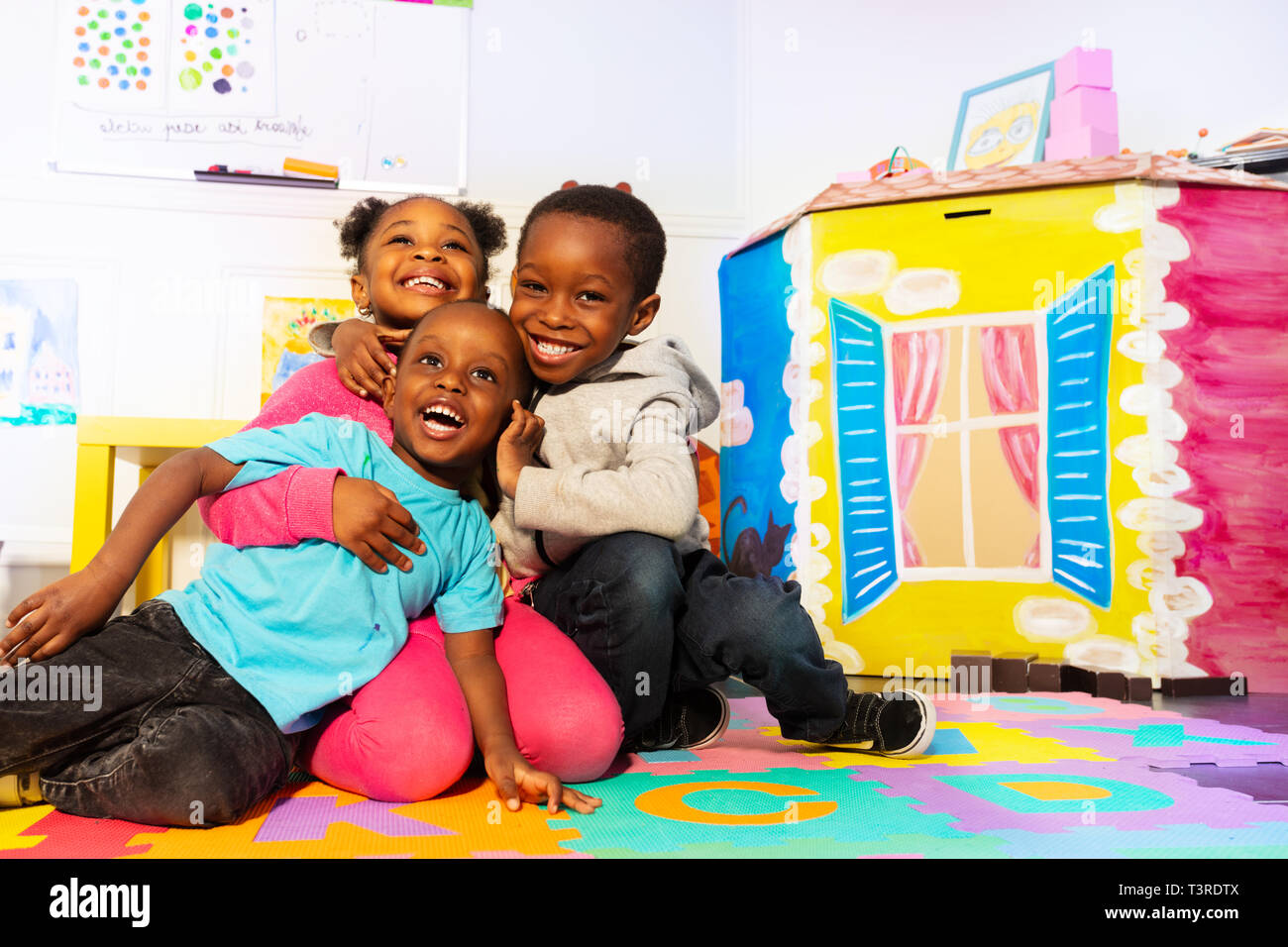 Kids play and hug in kindergarten room Stock Photo - Alamy