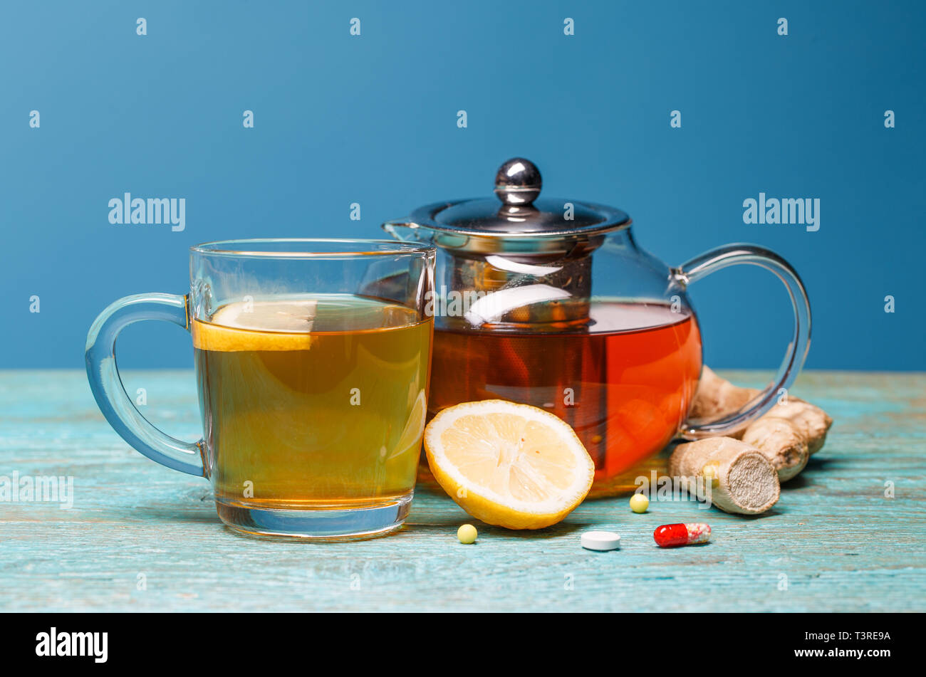 Cold medicines, tea, lemon and ginger on wooden blue background Stock ...