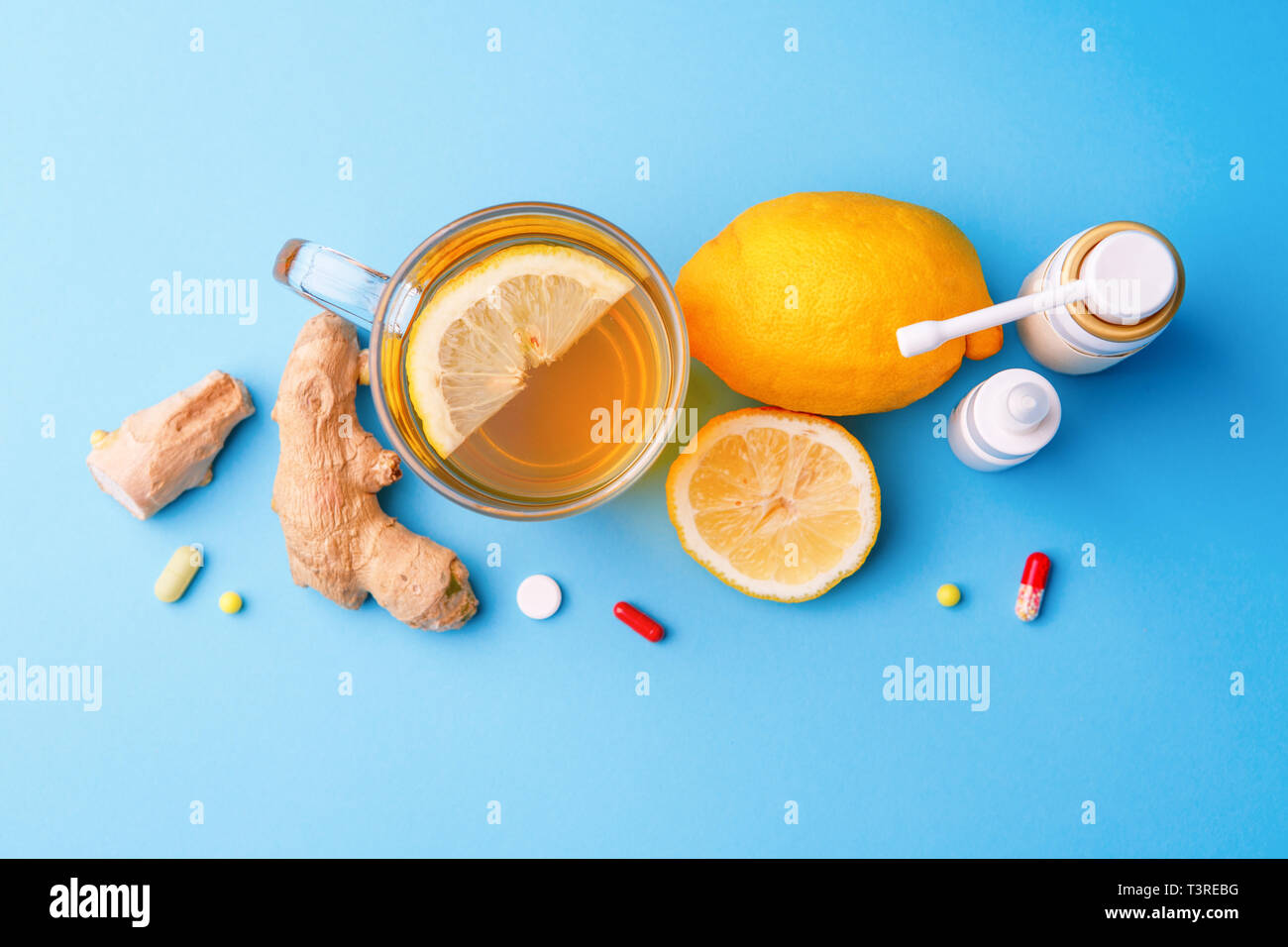 Cold medicines, tea, lemon and ginger on a blue background Stock Photo ...