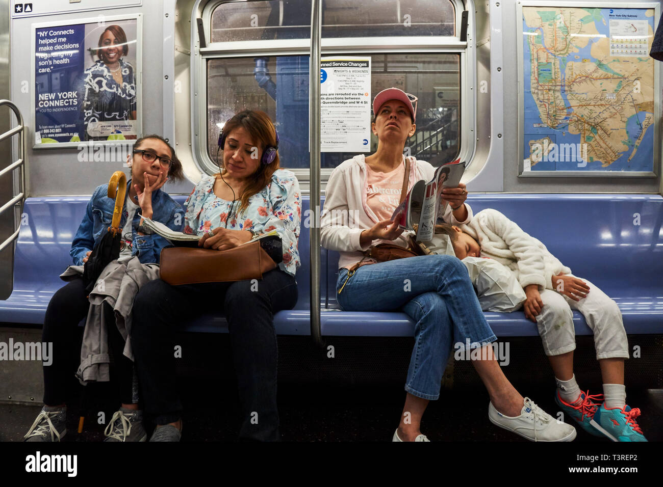 two mothers and their teenager kids riding into the NYC Subway Stock ...