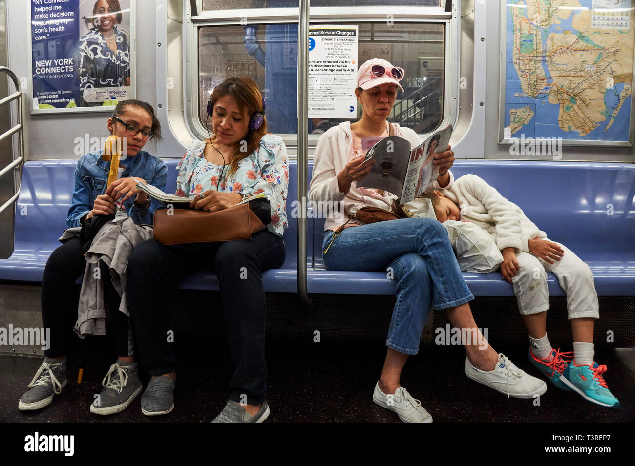 two mothers and their teenager kids riding into the NYC Subway Stock ...