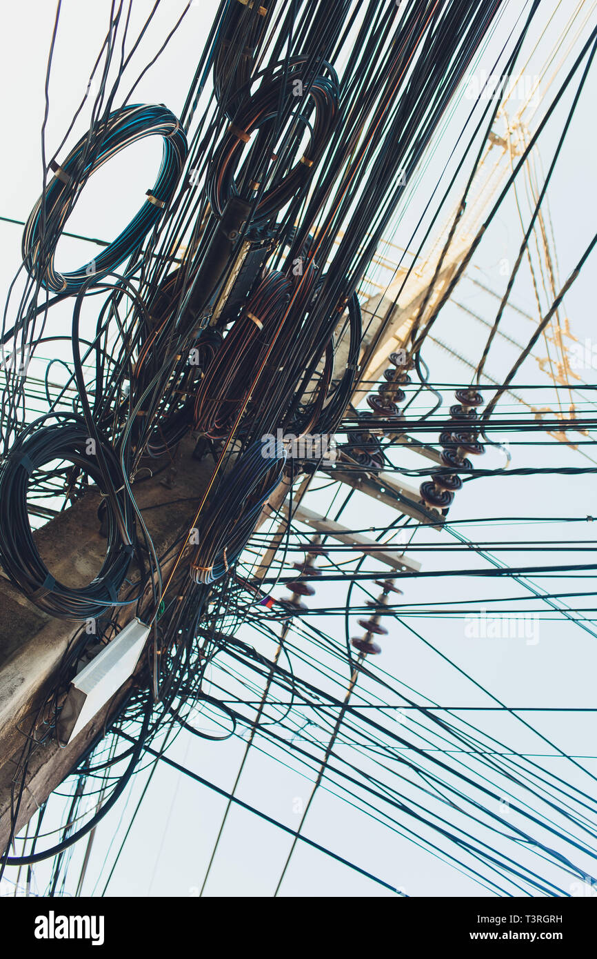 Crazy messy chaos wires cables on Electric poles Stock Photo - Alamy
