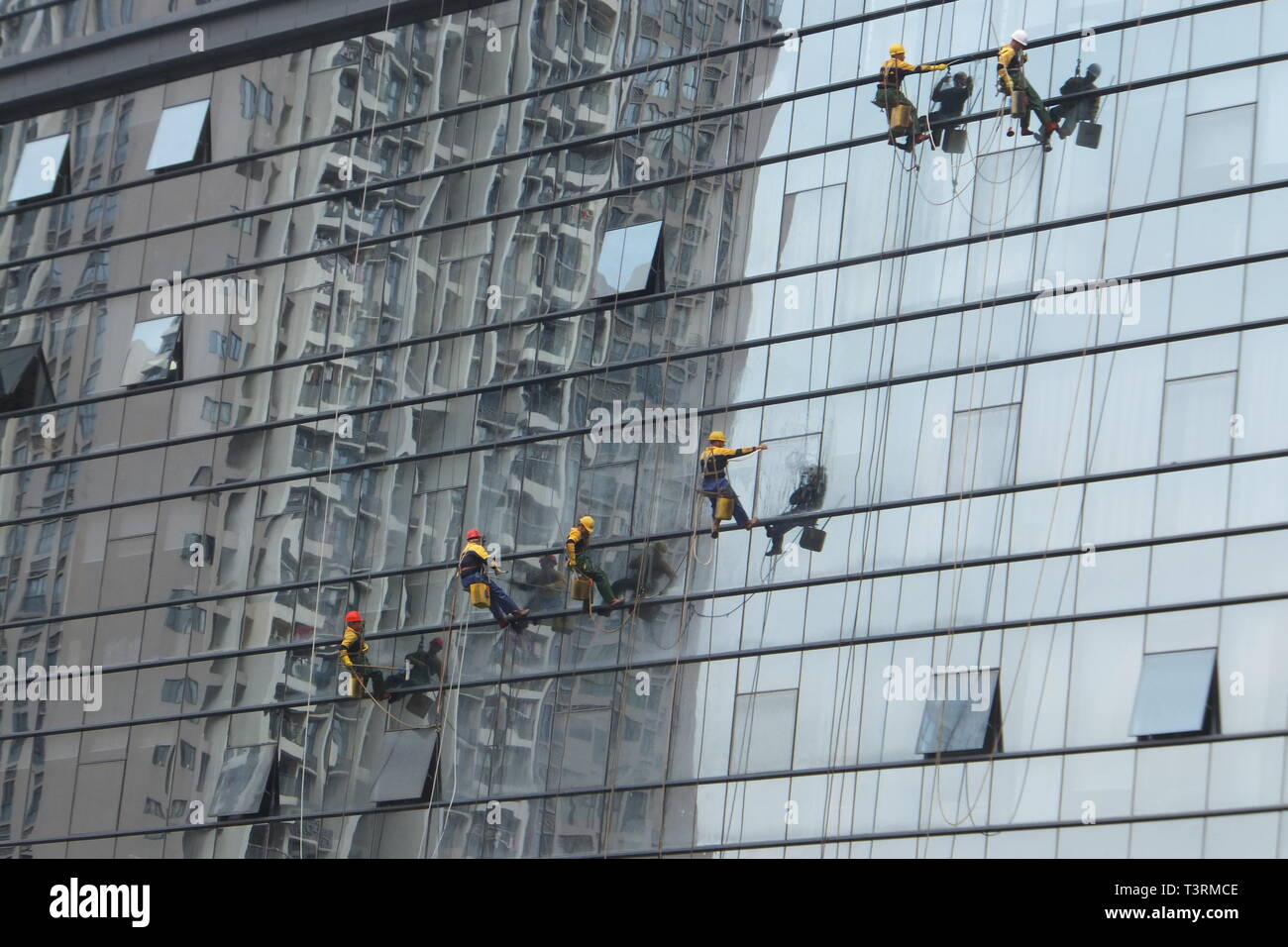 Workers clean the glass facade of a skyscraper in shenzhen, China Stock ...