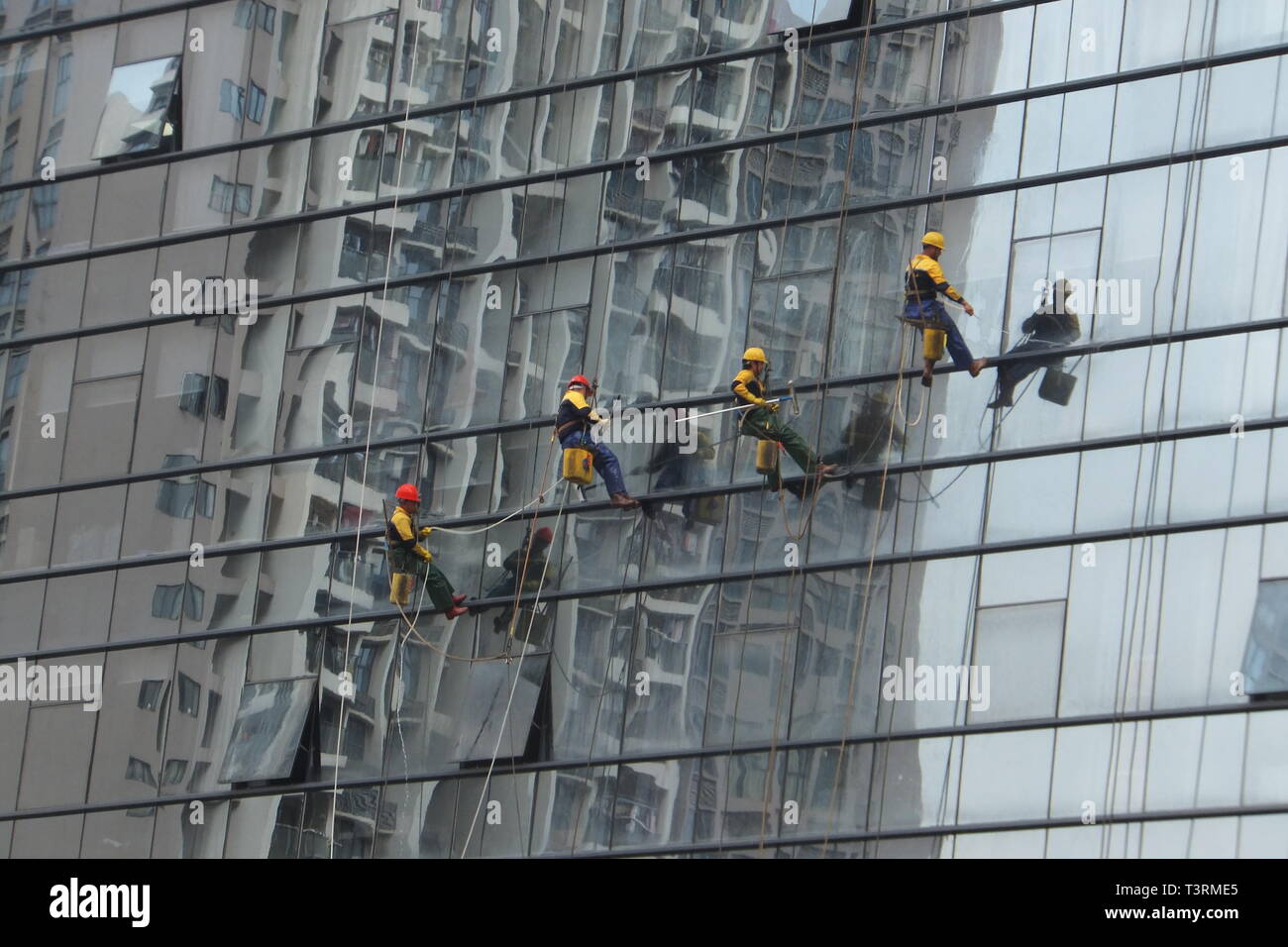 Workers clean the glass facade of a skyscraper in shenzhen, China Stock ...