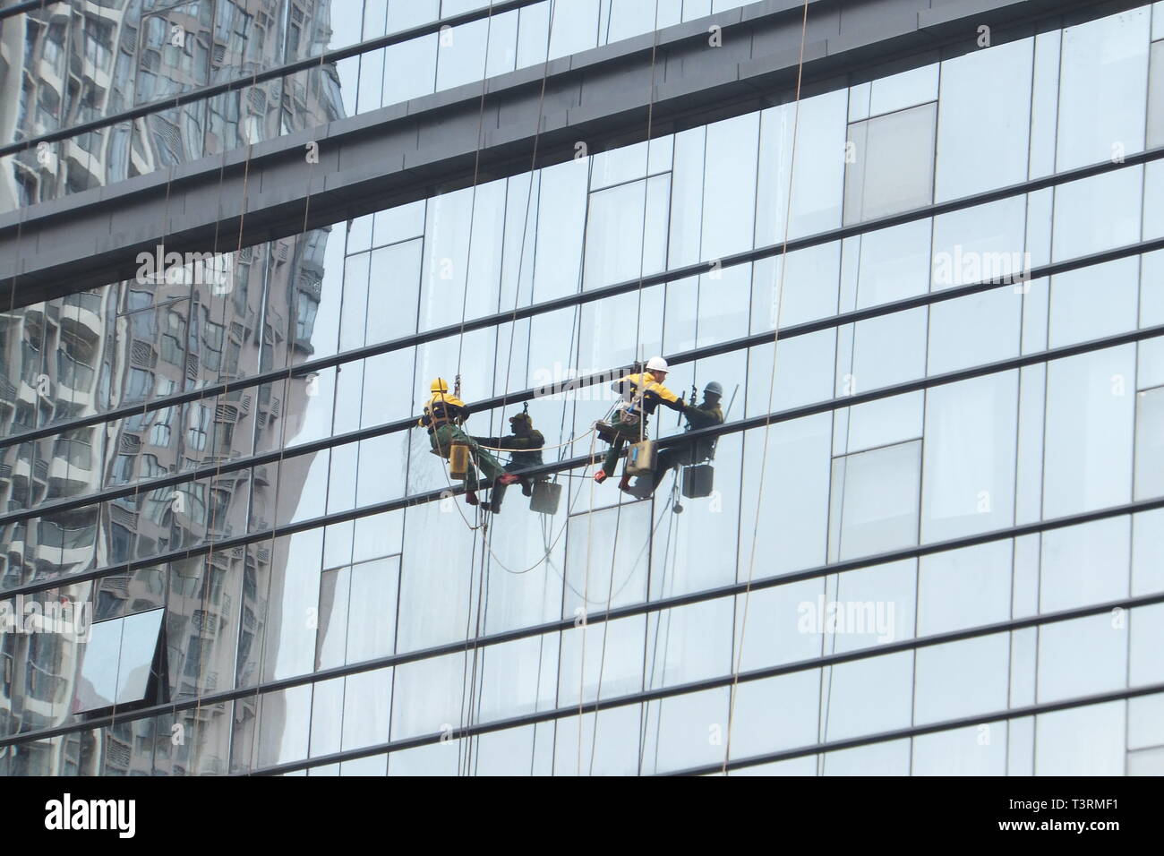 Workers clean the glass facade of a skyscraper in shenzhen, China Stock ...