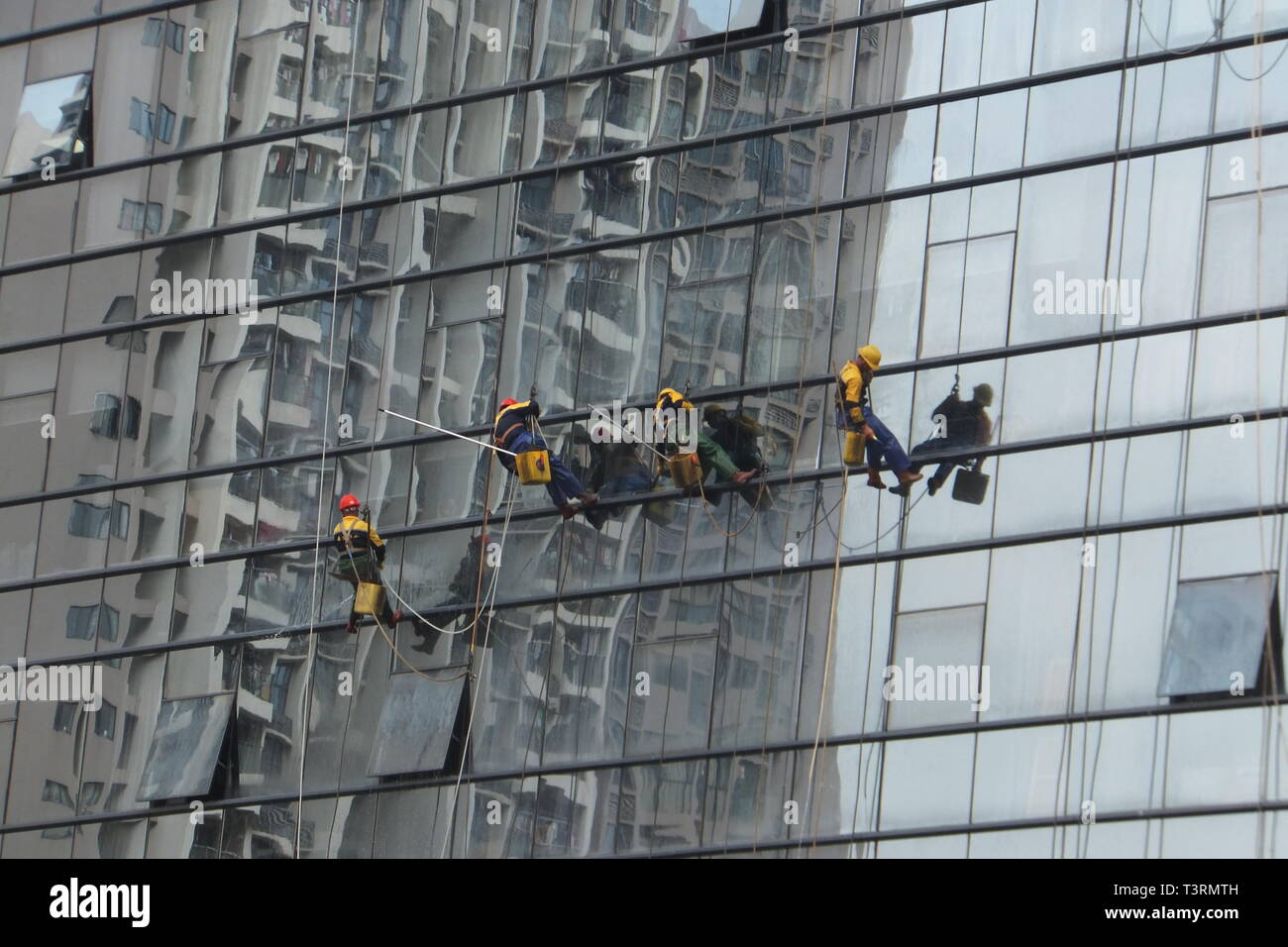 Workers clean the glass facade of a skyscraper in shenzhen, China Stock ...