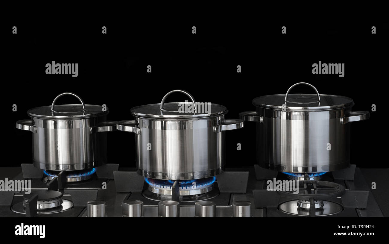 Metal pots in the kitchen, gas stove on, blue flame burning Stock Photo ...
