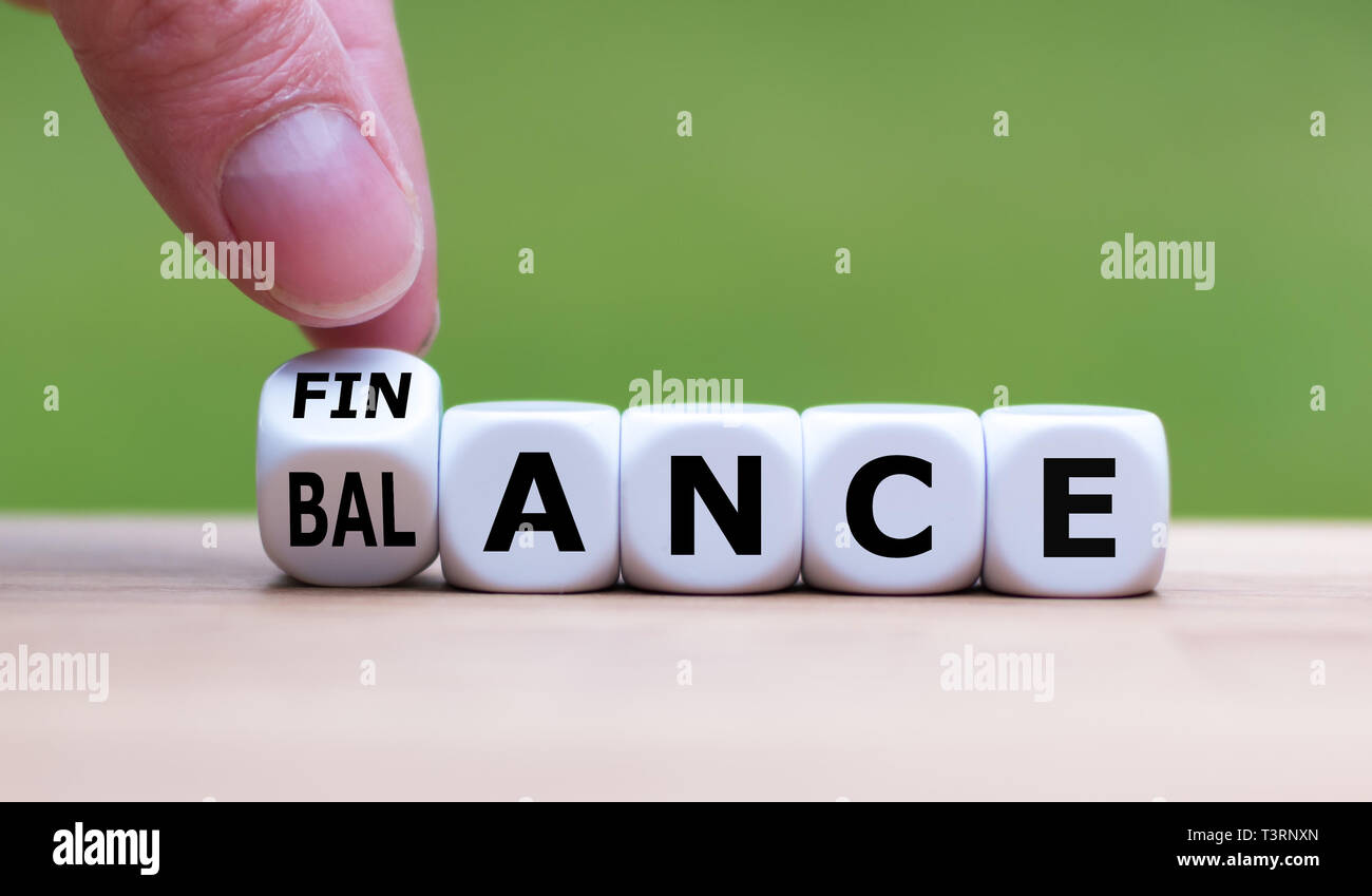 Symbol for finding the right balance in your finance. Hand turns a dice ...