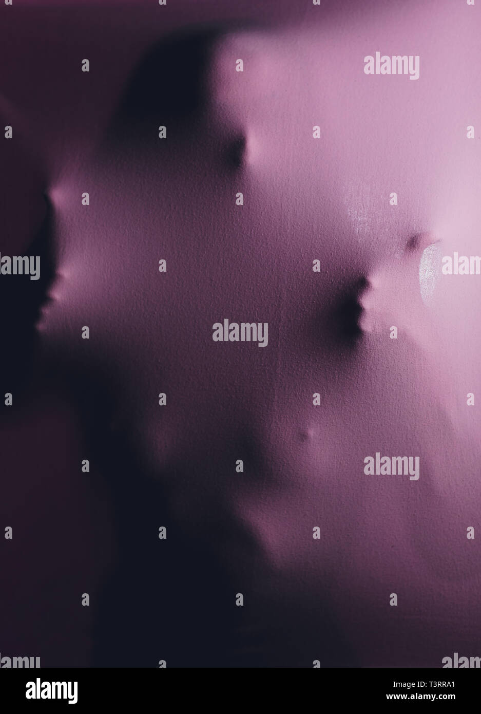 Art photo of a female silhouette breaking through the fabric. Struggle ...