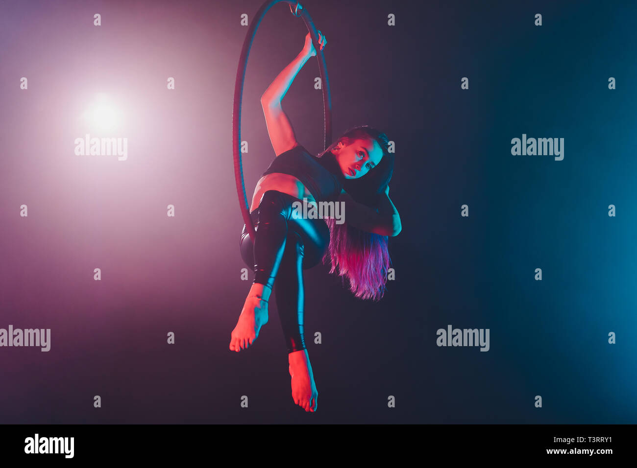 Aerial acrobat in the ring. A young girl performs the acrobatic ...