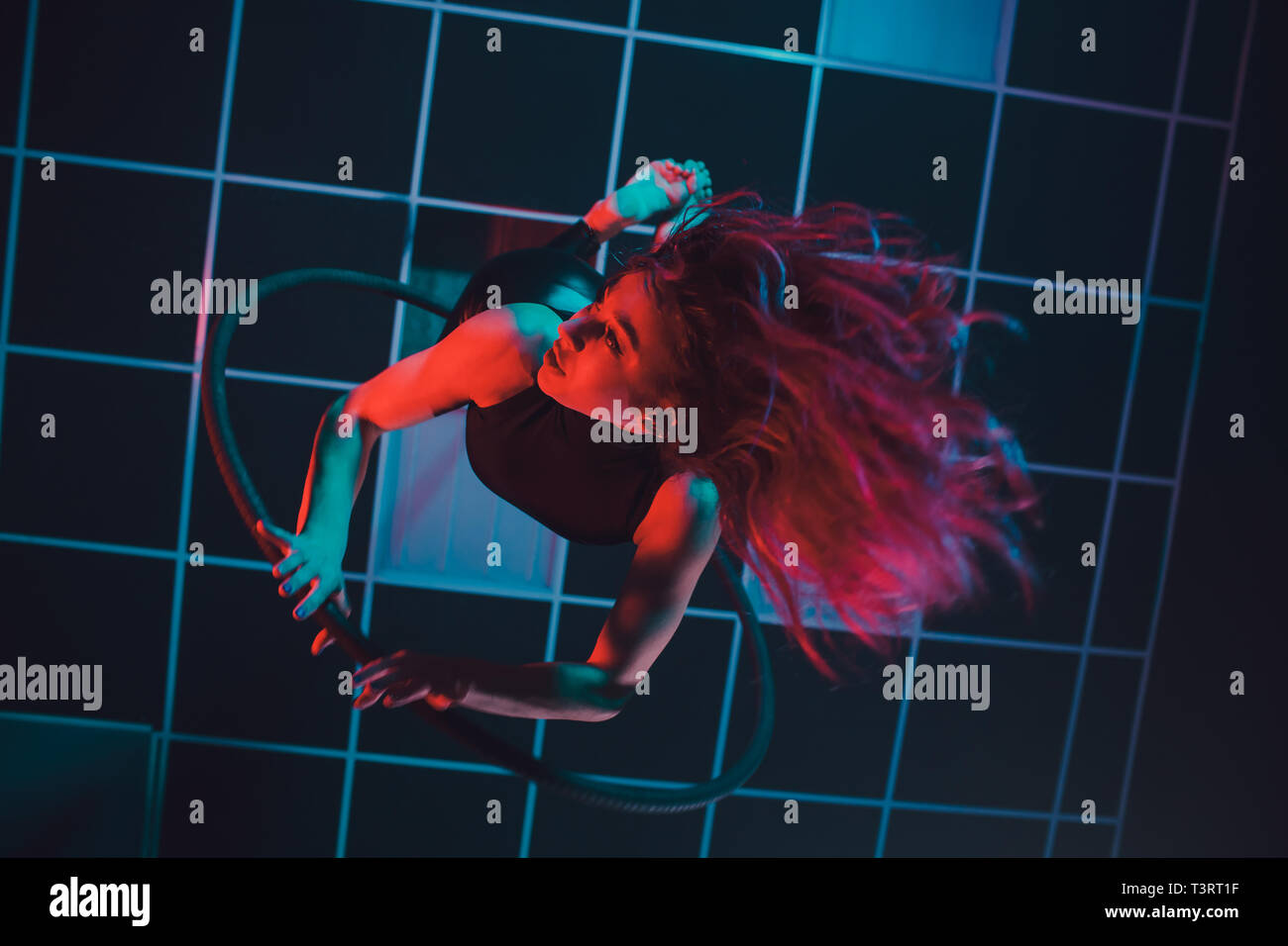 Aerial acrobat in the ring. A young girl performs the acrobatic ...