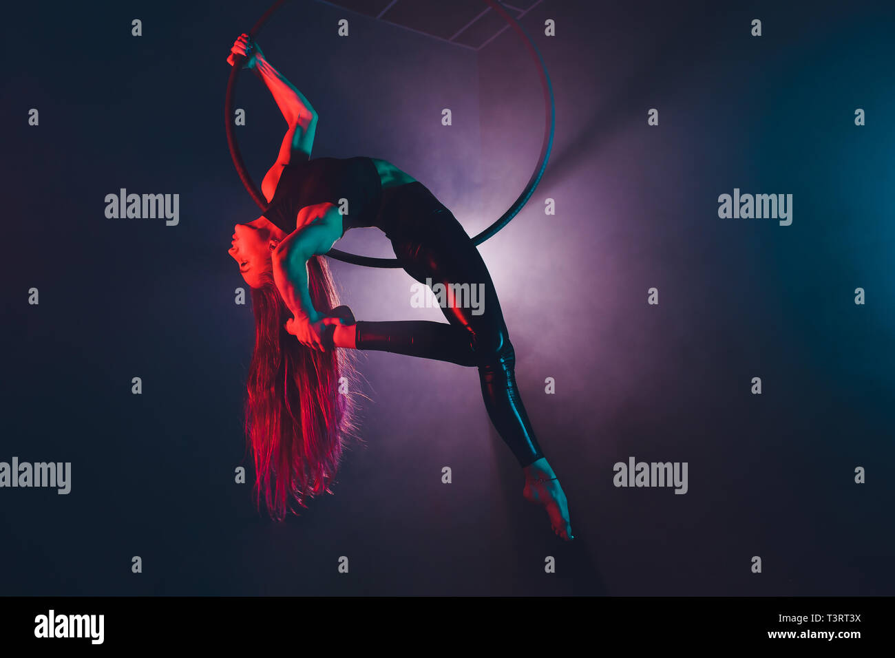 Aerial acrobat in the ring. A young girl performs the acrobatic ...
