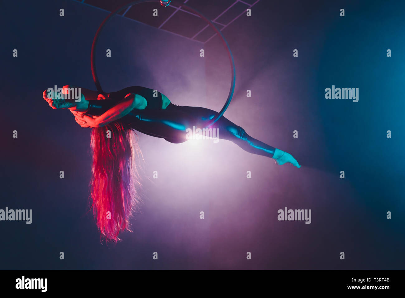 Aerial acrobat in the ring. A young girl performs the acrobatic ...