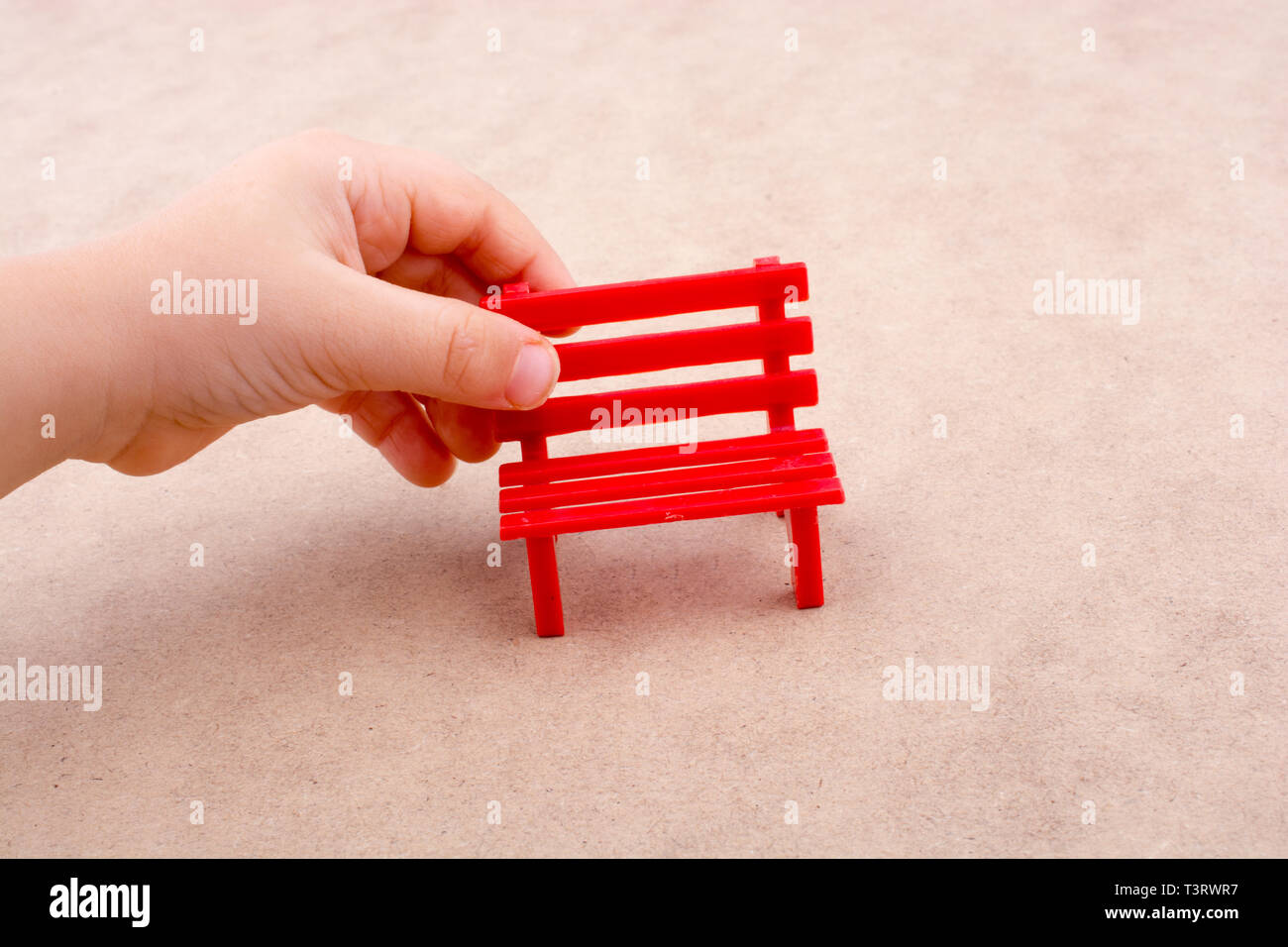 Little red miniature bench made of plastic Stock Photo - Alamy