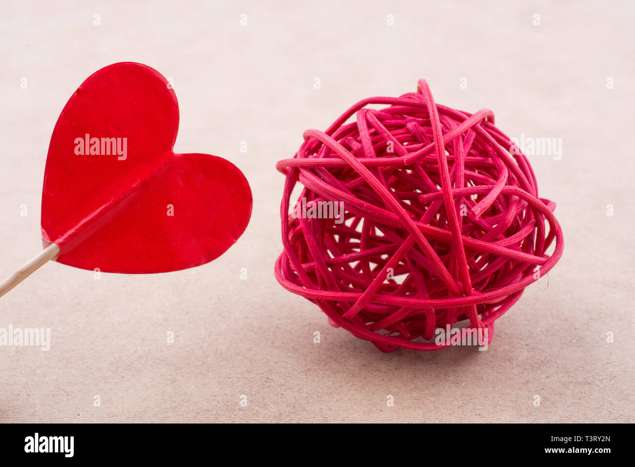 Little red color heart shape at the top of a stick and a red straw ...