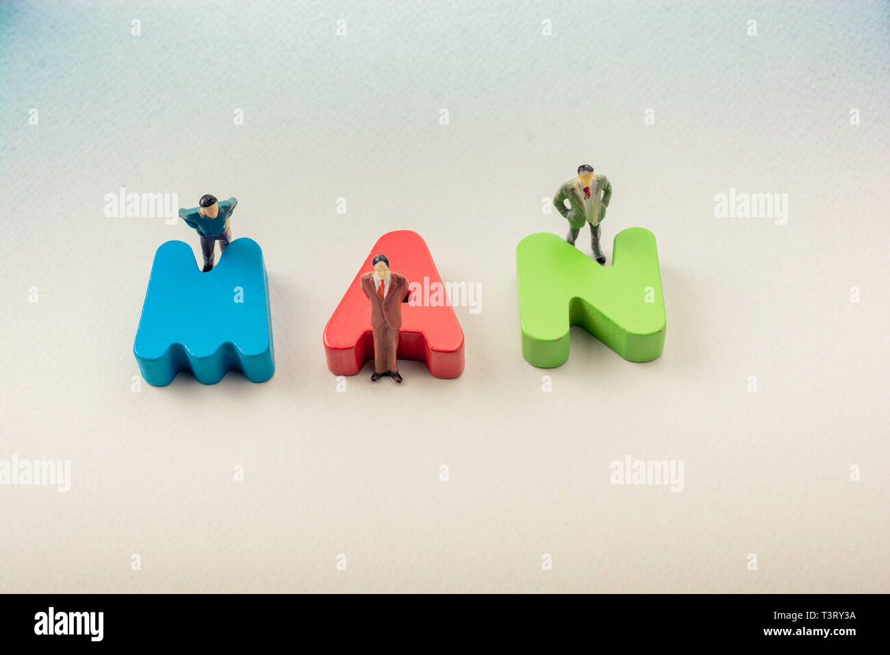 Tiny figurine of men beside colorful wooden letters say MAN Stock Photo ...
