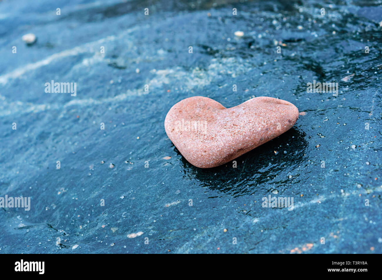 red stone heart, heart-shaped stone on dark background Stock Photo - Alamy