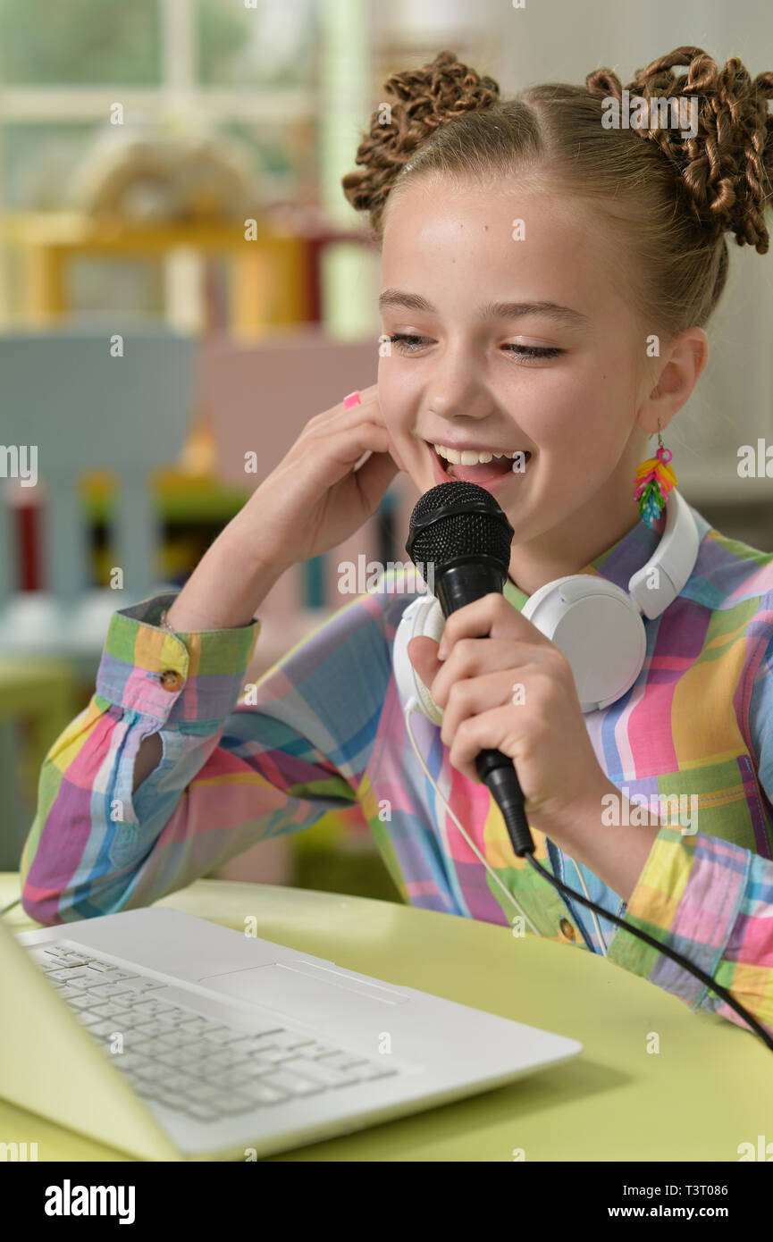 Cute little girl singing karaoke with laptop at her room Stock Photo ...